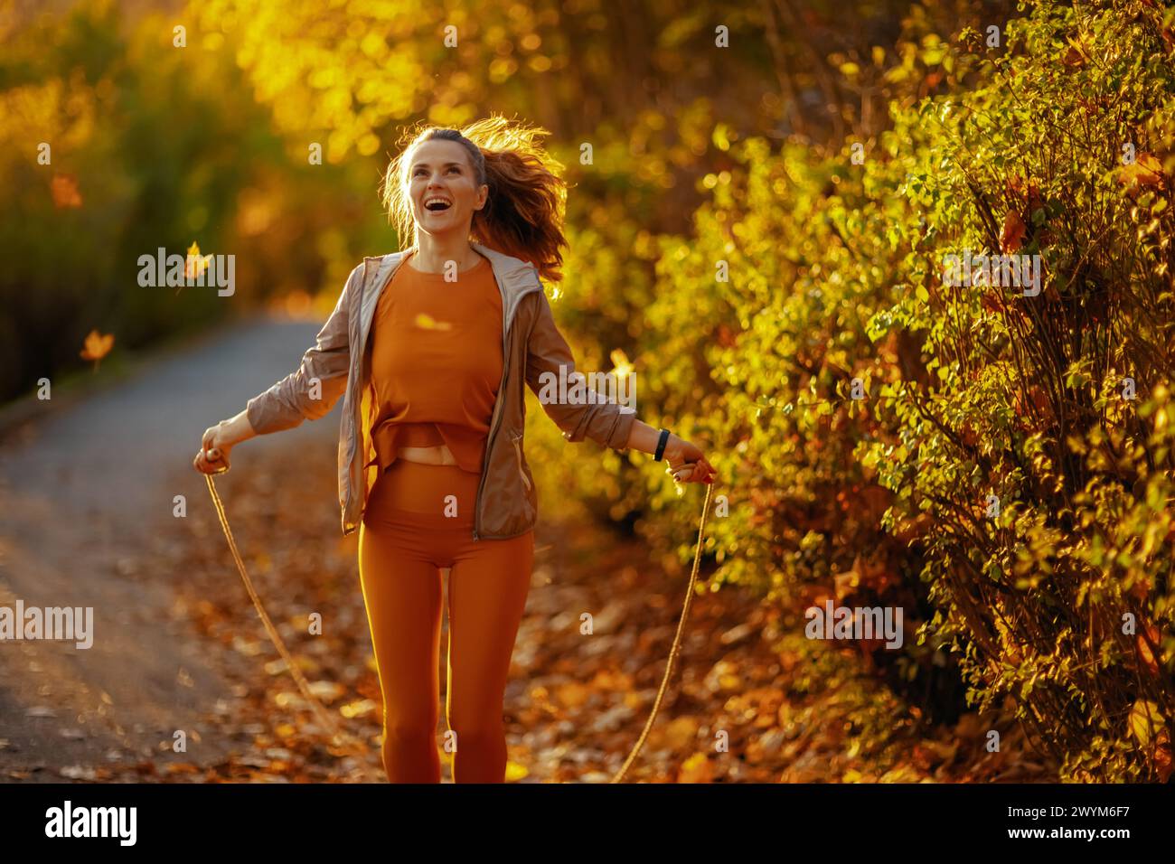 Hello autumn. happy trendy woman in fitness clothes in the park with ...