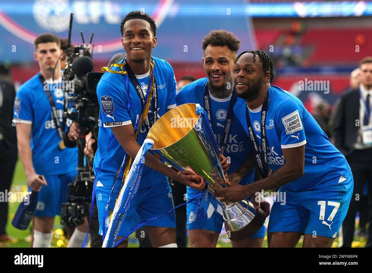 Peterborough United's Ricky Jade-Jones (right) and team-mates lift the ...