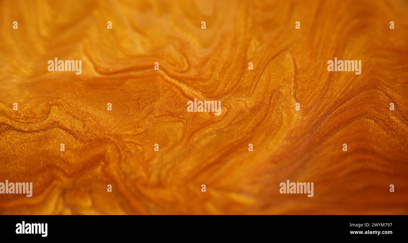 Liquid glitter. Shiny paint texture. Defocused golden color sparkling ...