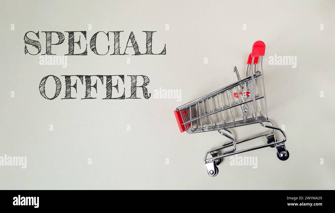 A shopping cart with a red handle is on a white background with the ...