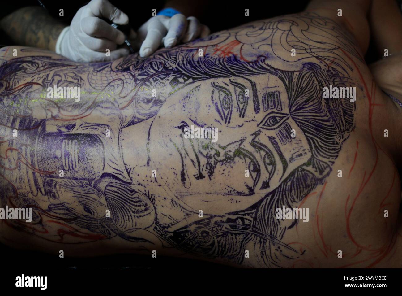 Lalitpur, Nepal. 05th Apr, 2024. A man gets inked on his back by a ...