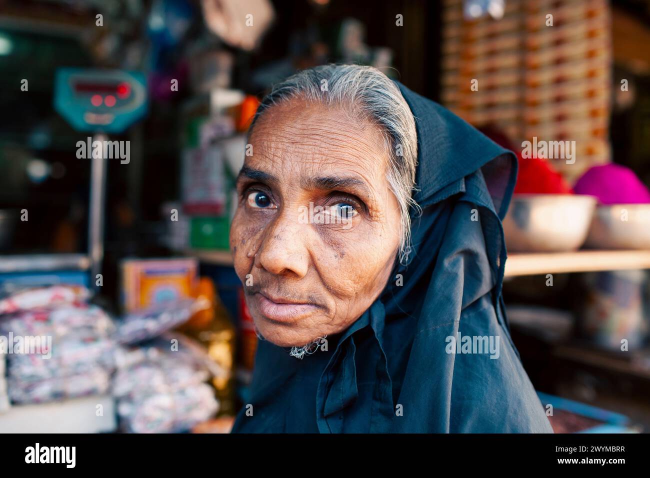 An elderly woman wearing a veil, face unveiled. Street photography in ...