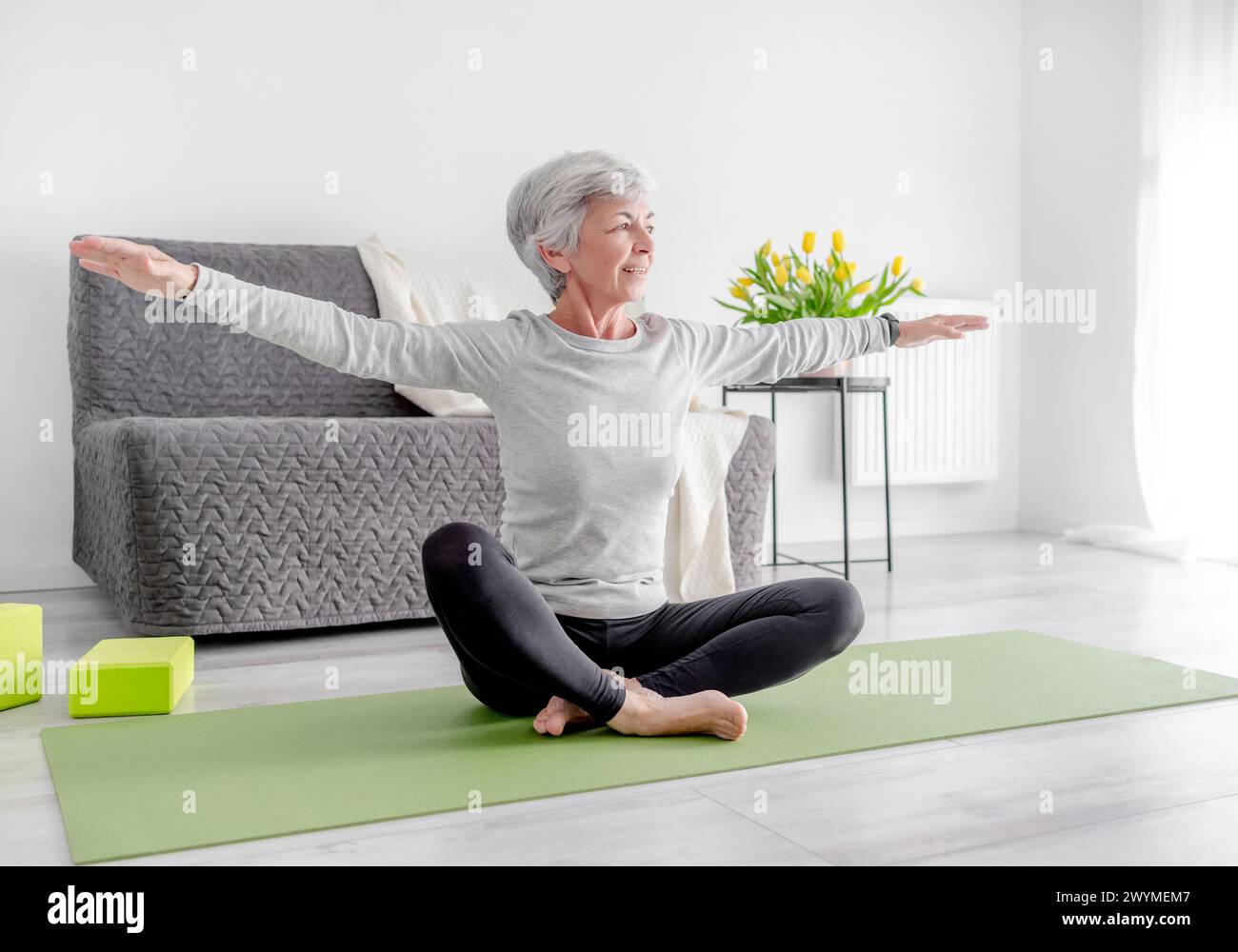 Calm Home Exercises In A Bright Room, A 70-Year-Old Woman Practices ...
