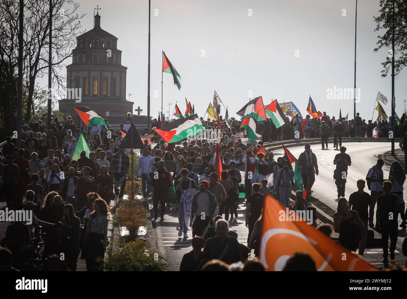Hundreds of protesters hold flags during a demonstration march. Close ...