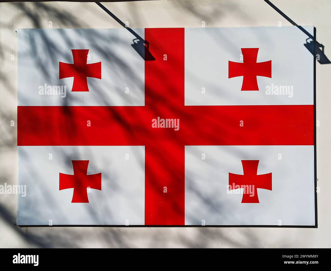 Large Georgian flag hanging on the white wall Stock Photo - Alamy