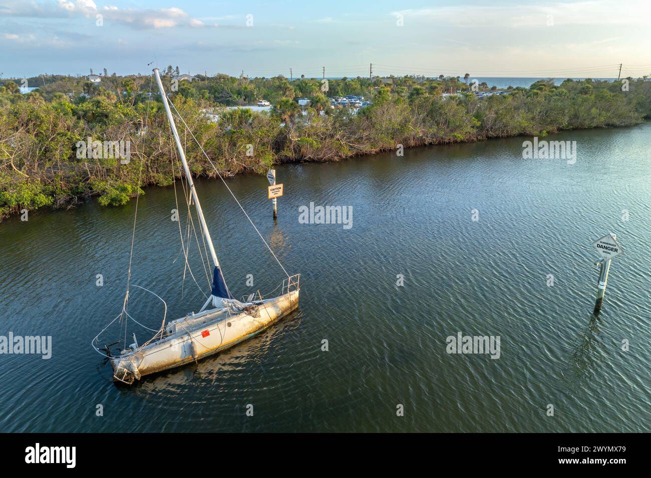 Capsized sunken sailing boat left forsaken on shallow bay waters after ...