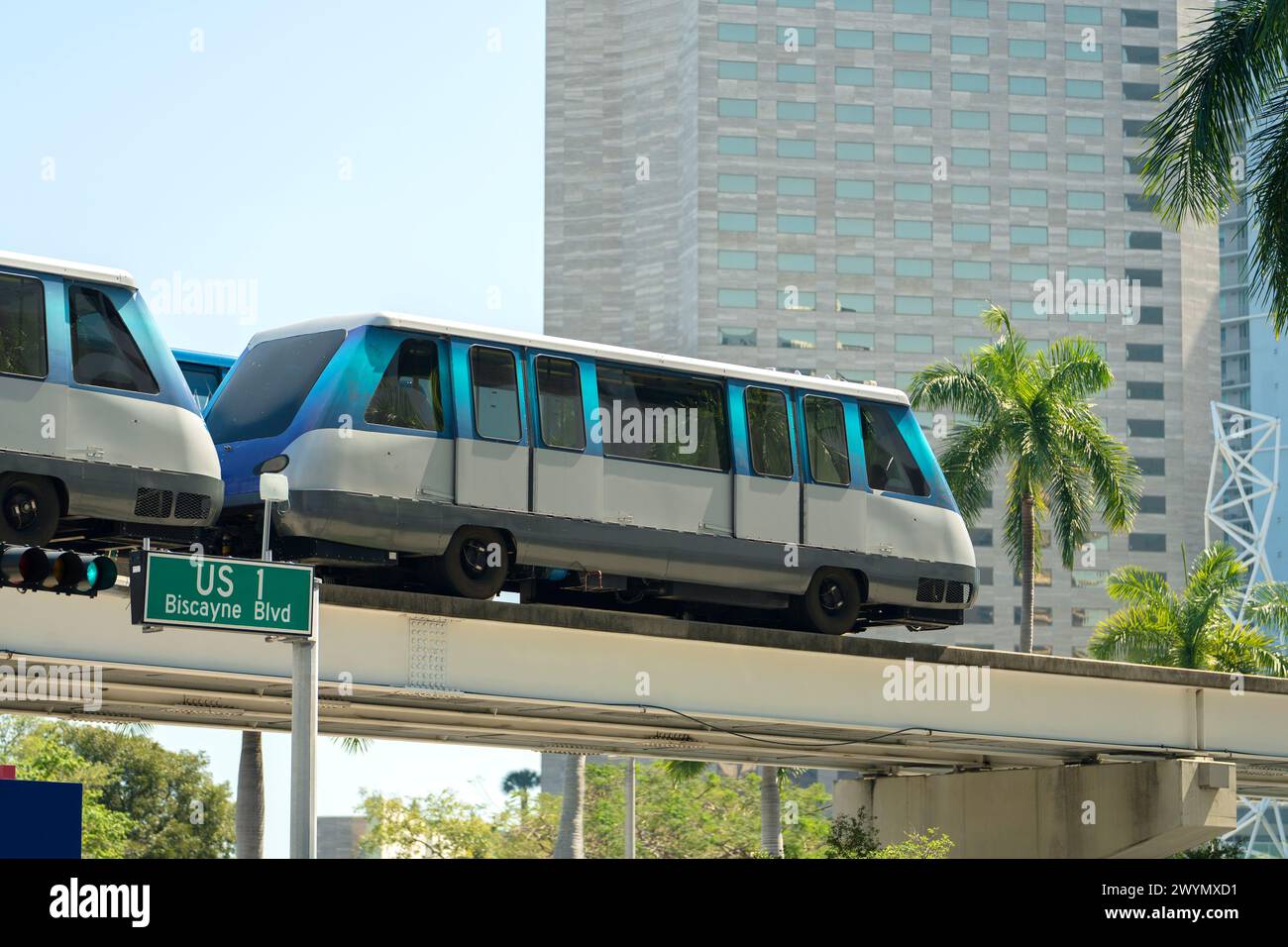 City train car on high railroad over street traffic between skyscraper ...