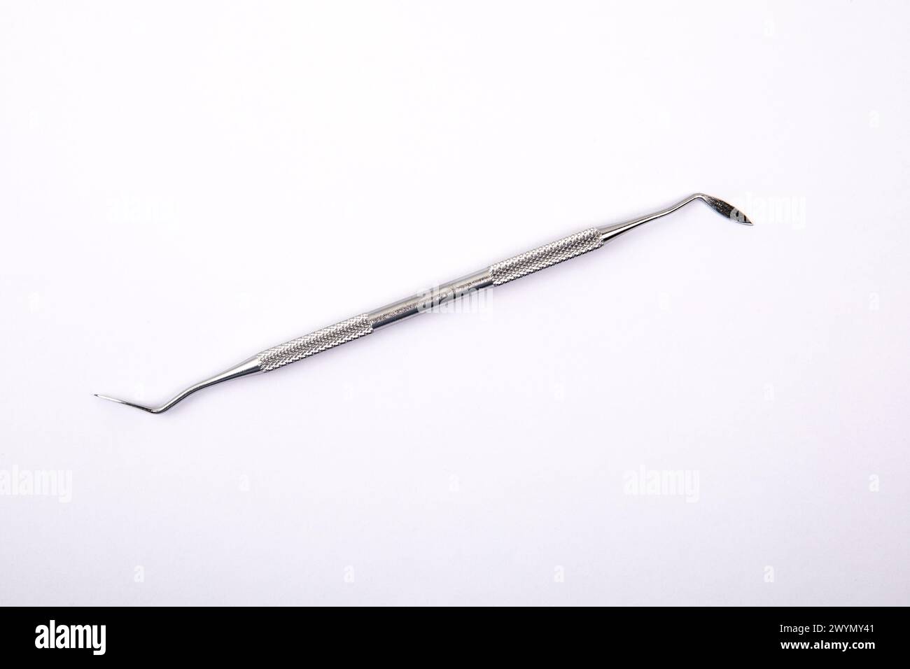 Dental instrument on a white background. Steel Stock Photo - Alamy