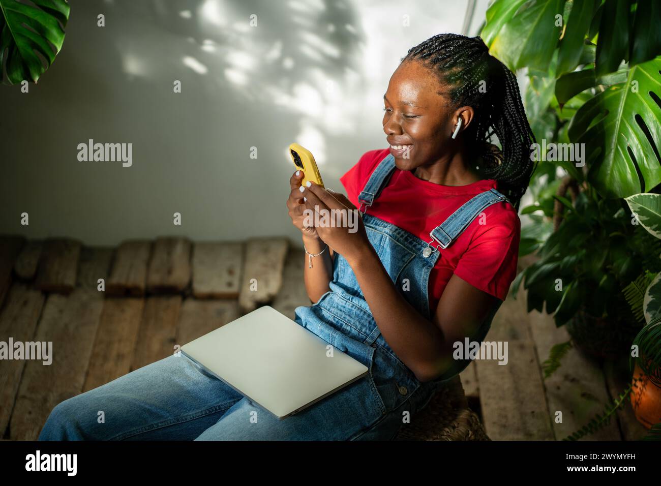 Cheerful black woman rest with cellphone smiling with closed laptop on ...