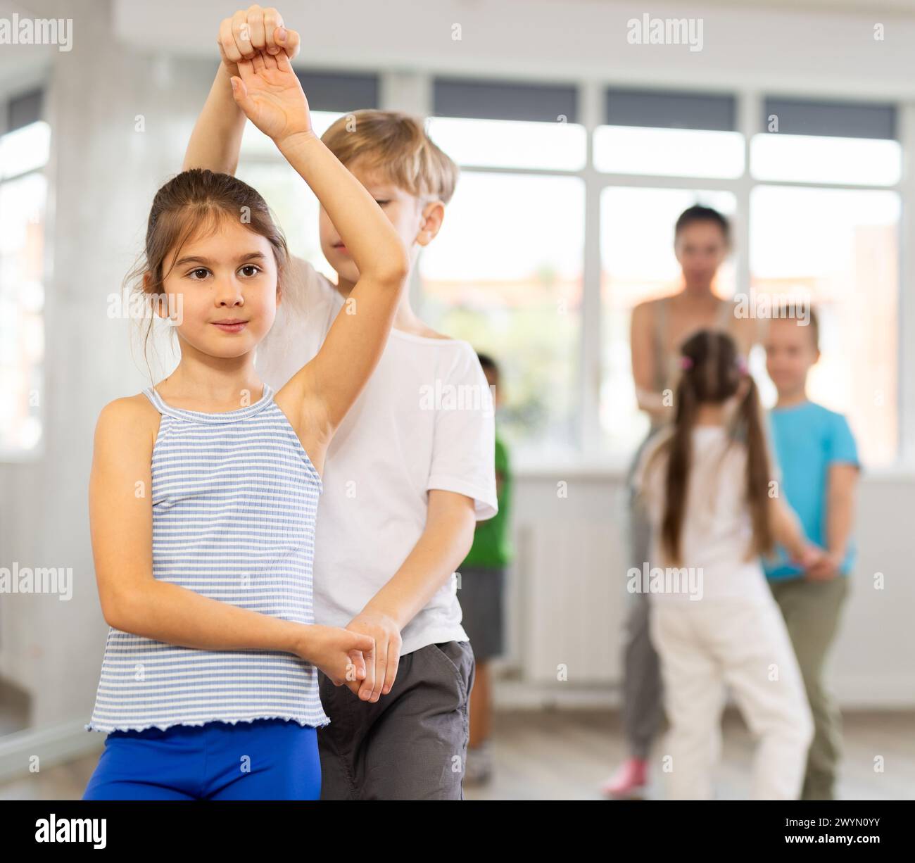Happy preteen children practicing ballroom dances in pairs in training ...