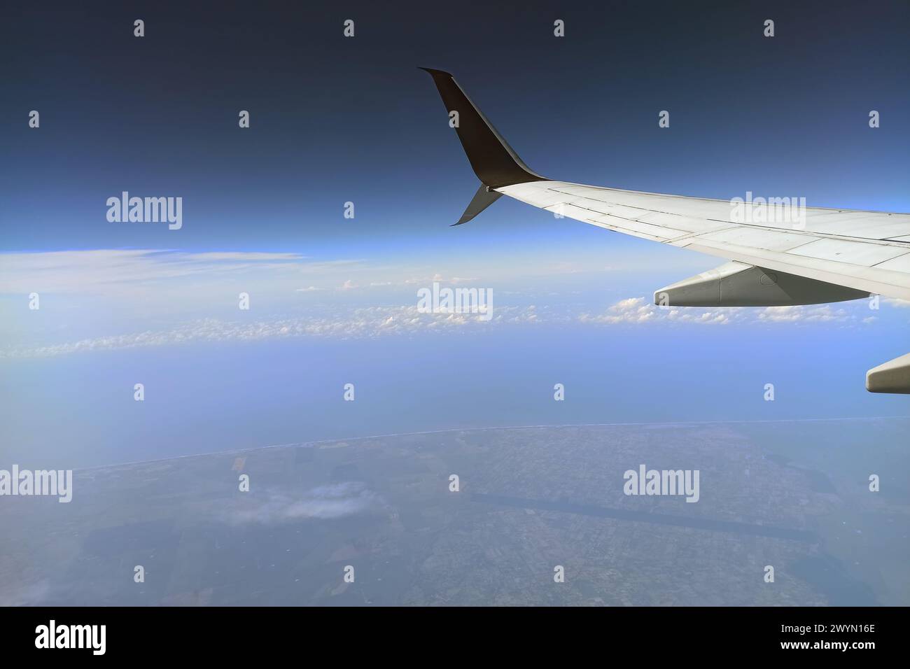 View through airplane window of commercial jet plane wing flying high ...