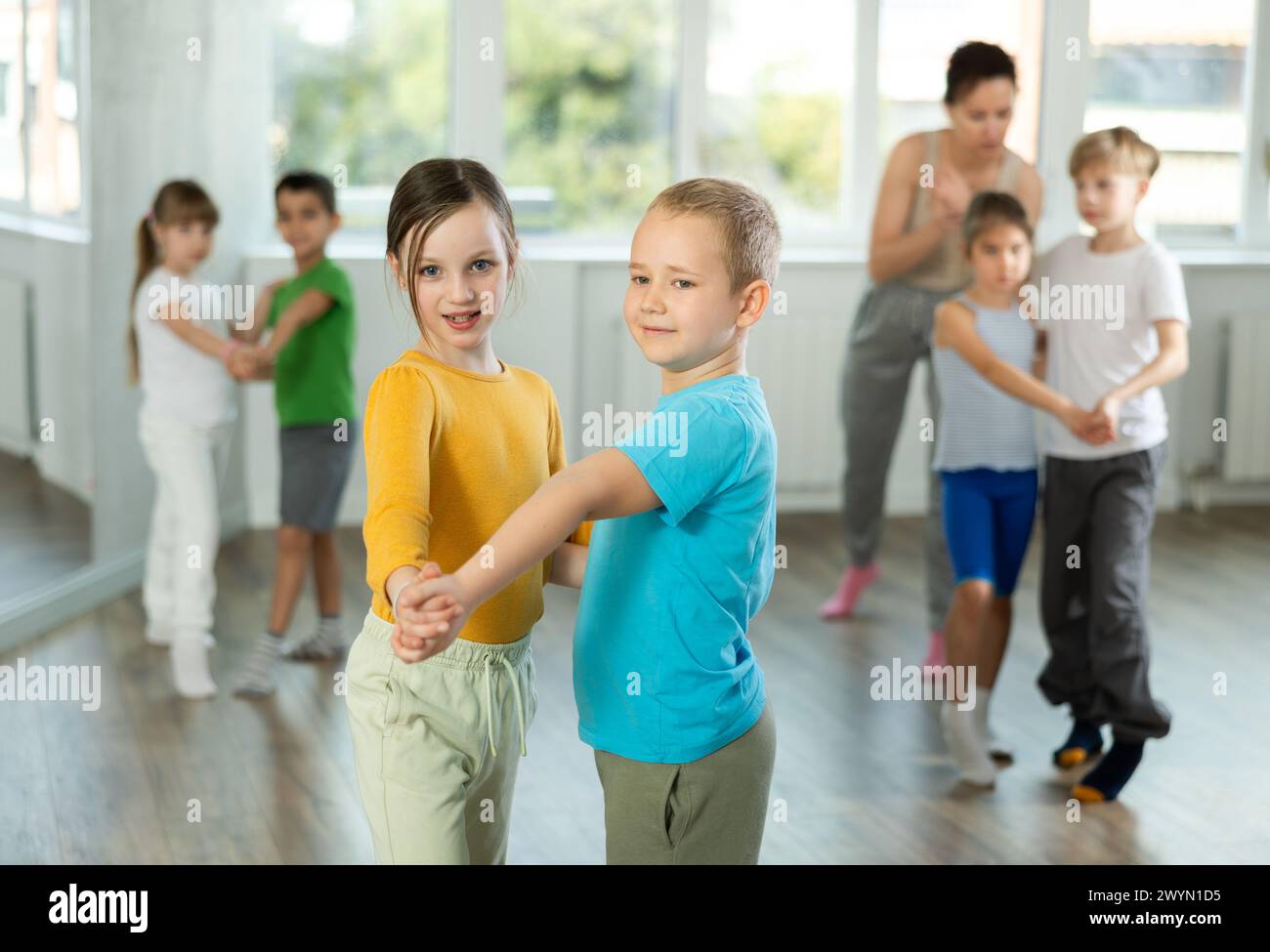 Preteen children learn to dance tango under guidance of a teacher in ...