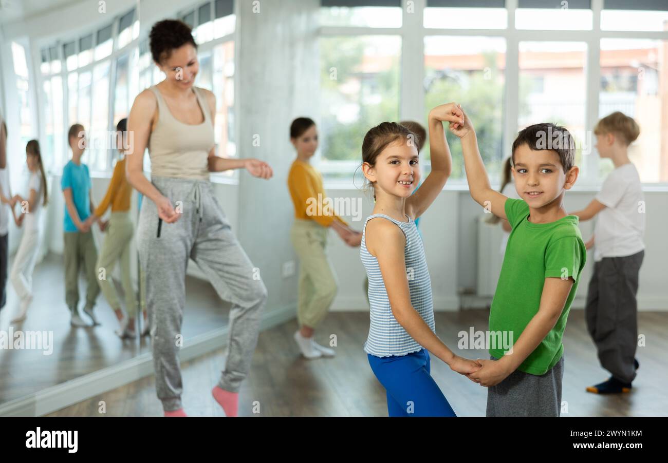 Preteen children learn to dance tango under guidance of a teacher in ...