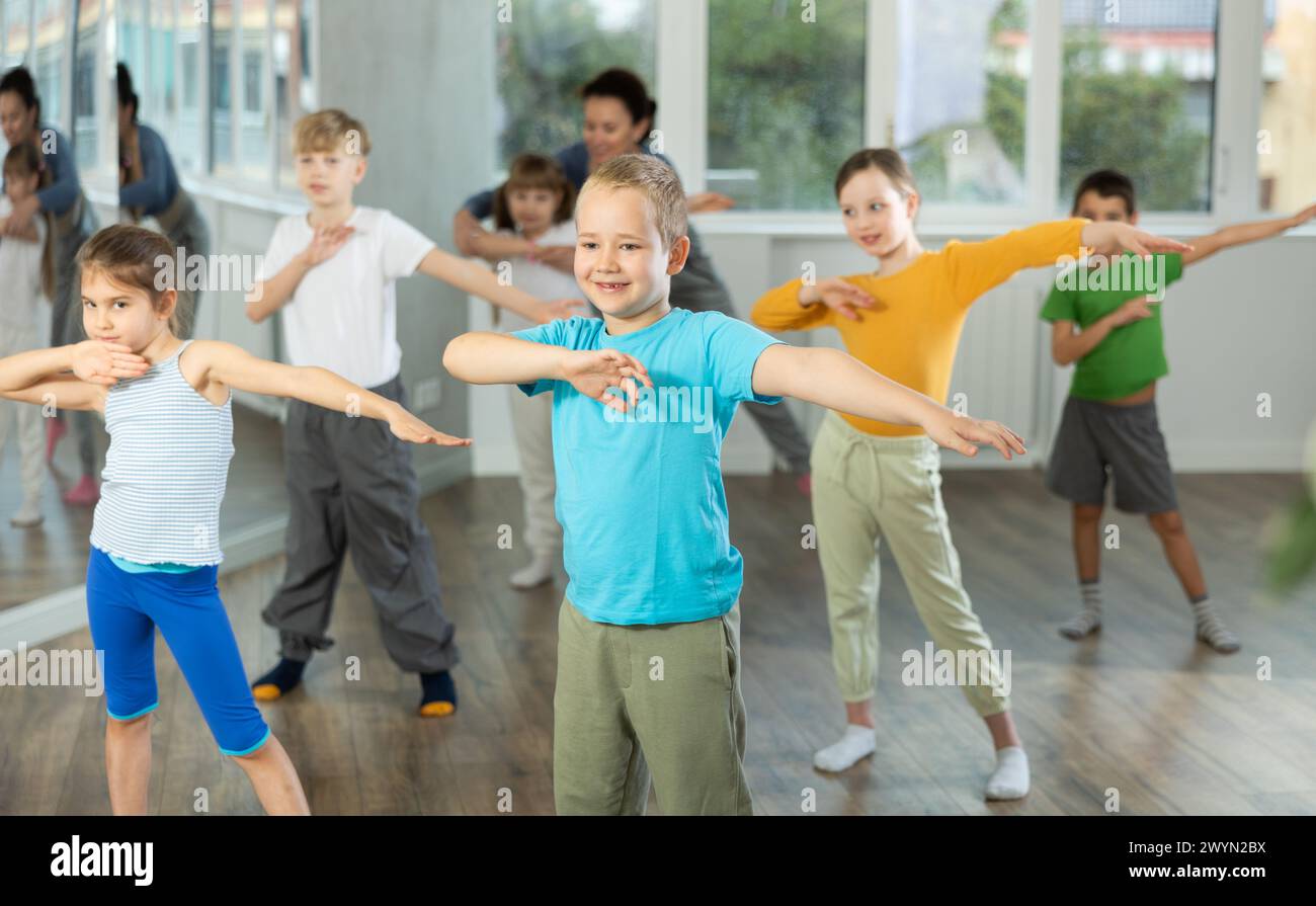 Group of preteen girls and boys enjoying active dance movement in ...