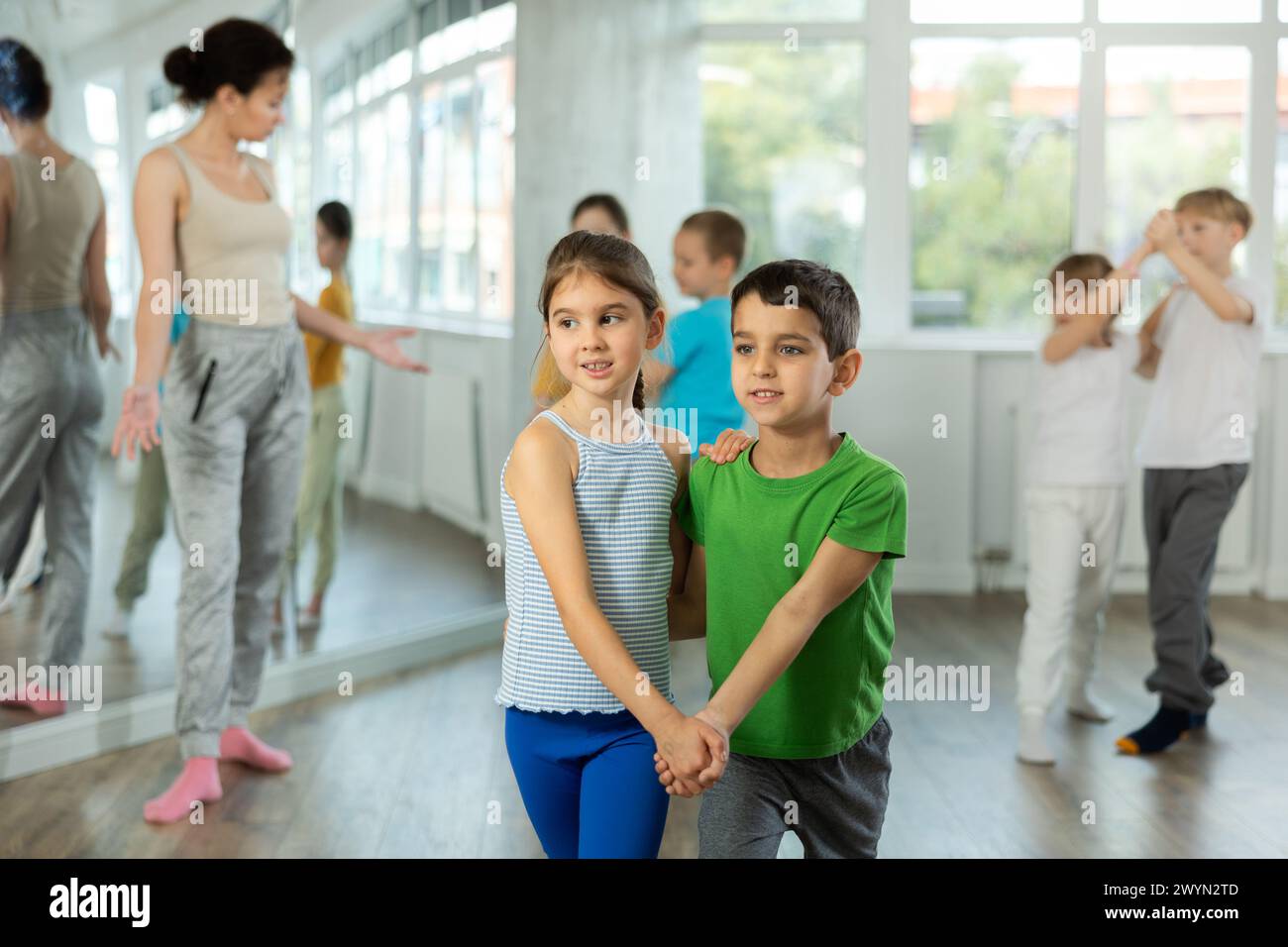 Preteen children learn to dance tango under guidance of a teacher in ...