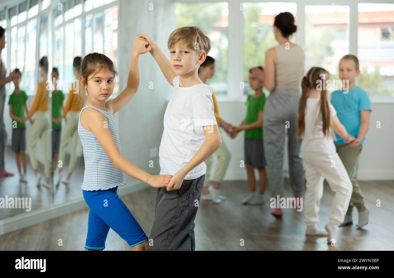 Preteen children learn to dance tango under guidance of a teacher in ...