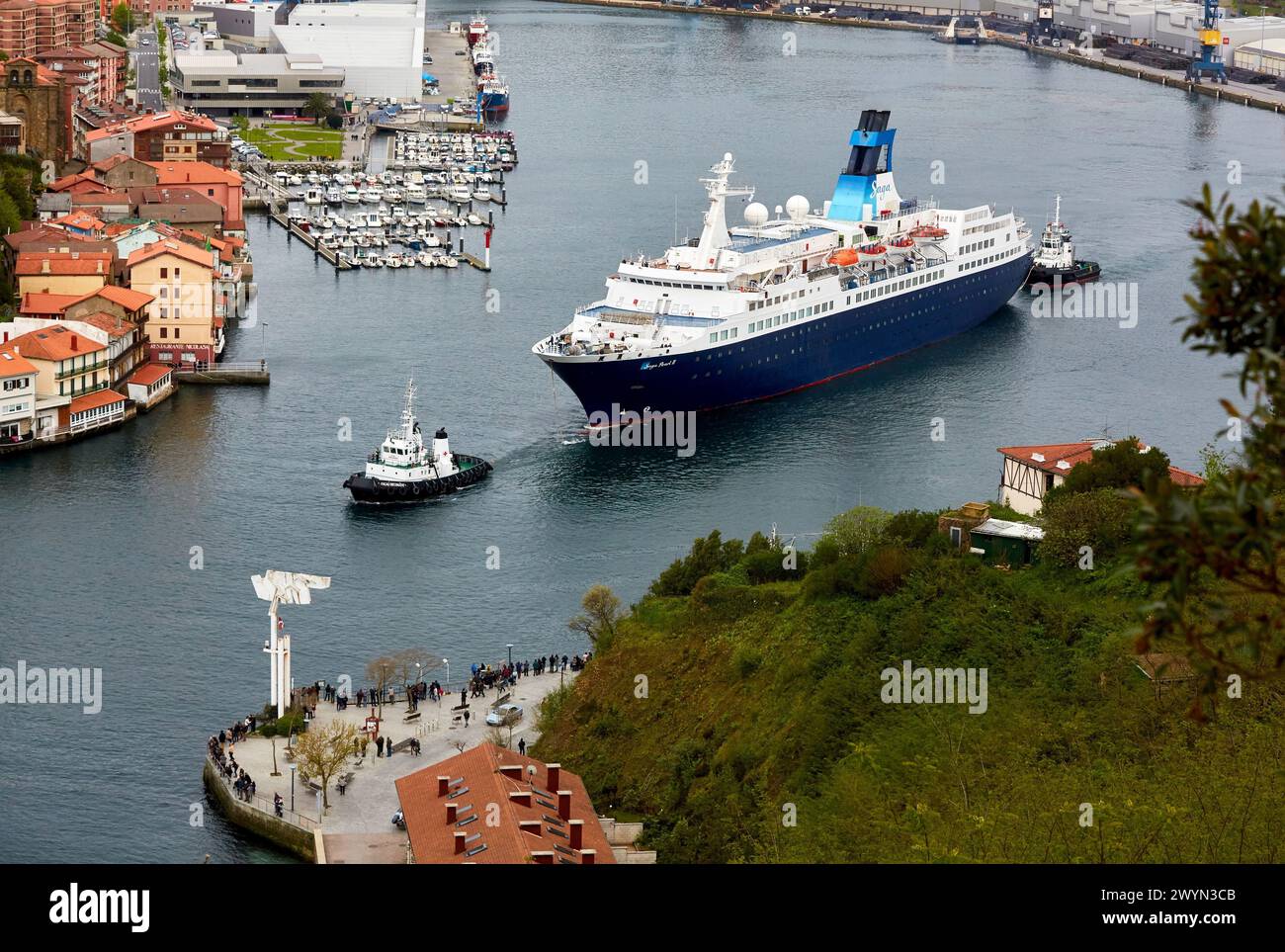 Tugboat and cruise liner. Passenger ship. Tug maneuvers. Pasaia Port ...