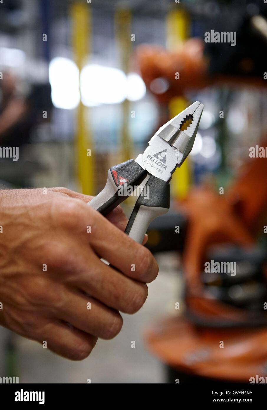 Hand holding pliers Stock Photo - Alamy