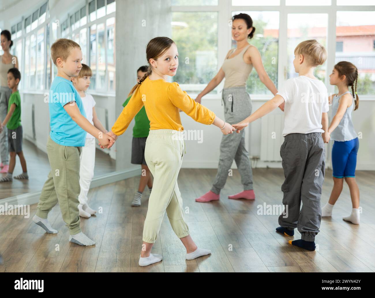 Group of children with teacher dance in circle Stock Photo - Alamy