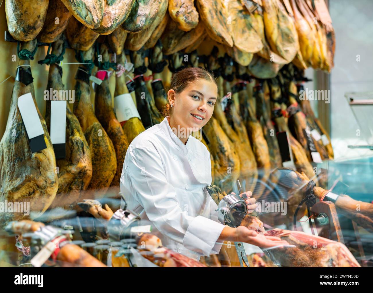Woman shop assistant demonstrating sorts of meat in butcher shop Stock ...