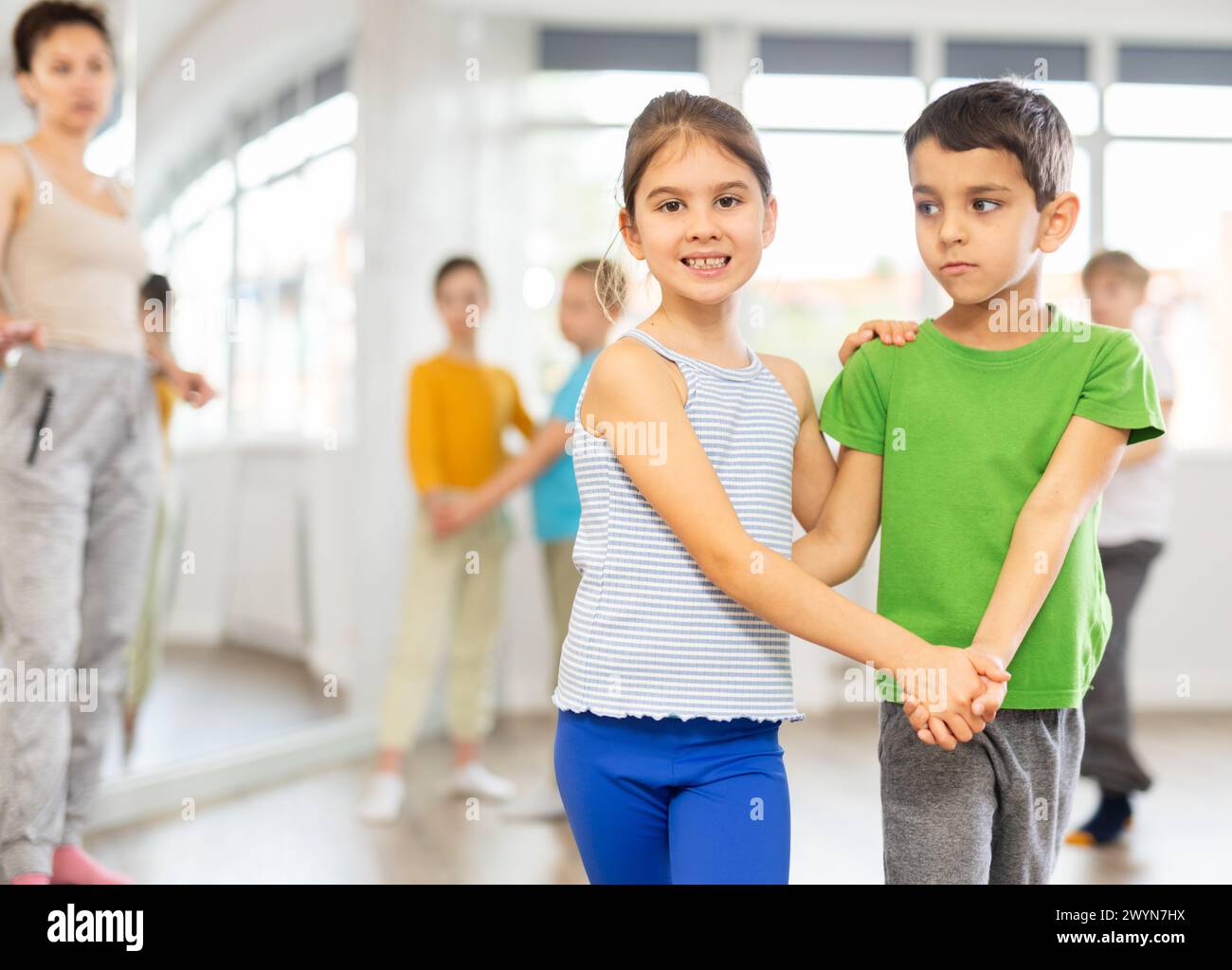 Group of preteen children training movements of slow foxtrot in dance ...