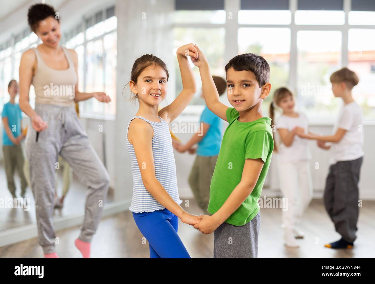 Group of preteen children training movements of slow foxtrot in dance ...