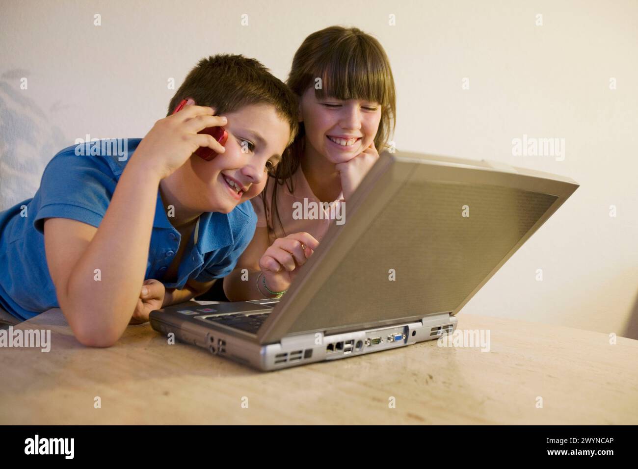 Children using portable computer and cell phone Stock Photo - Alamy