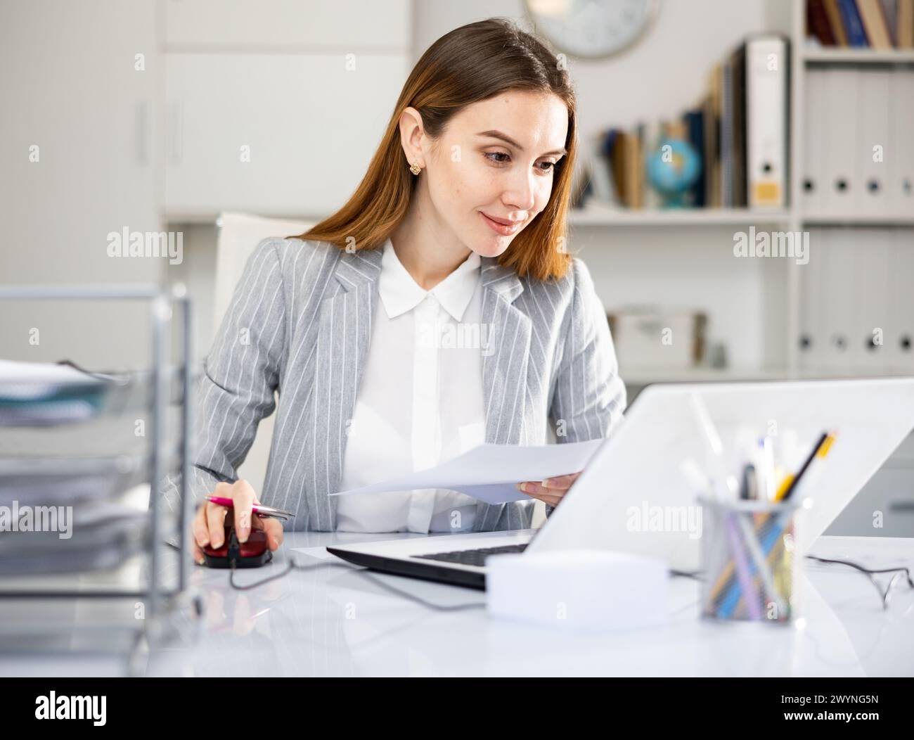 Woman office worker using laptop during workday Stock Photo - Alamy