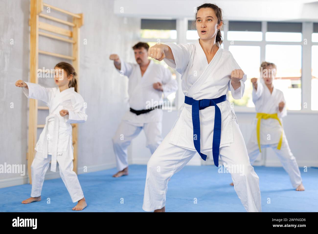 Woman practicing kata routine during family training at karate class ...