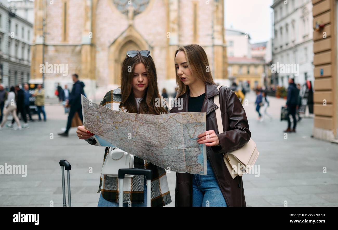 Two female tourists engage in lively discussion, surrounded by their ...