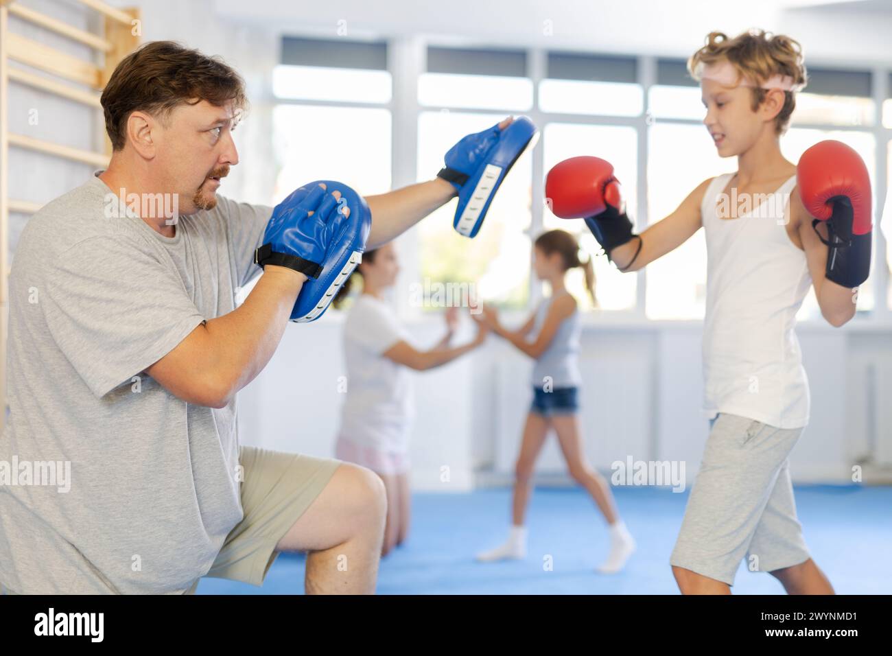 Man holding hitting pads during boxing workout with tween son Stock ...
