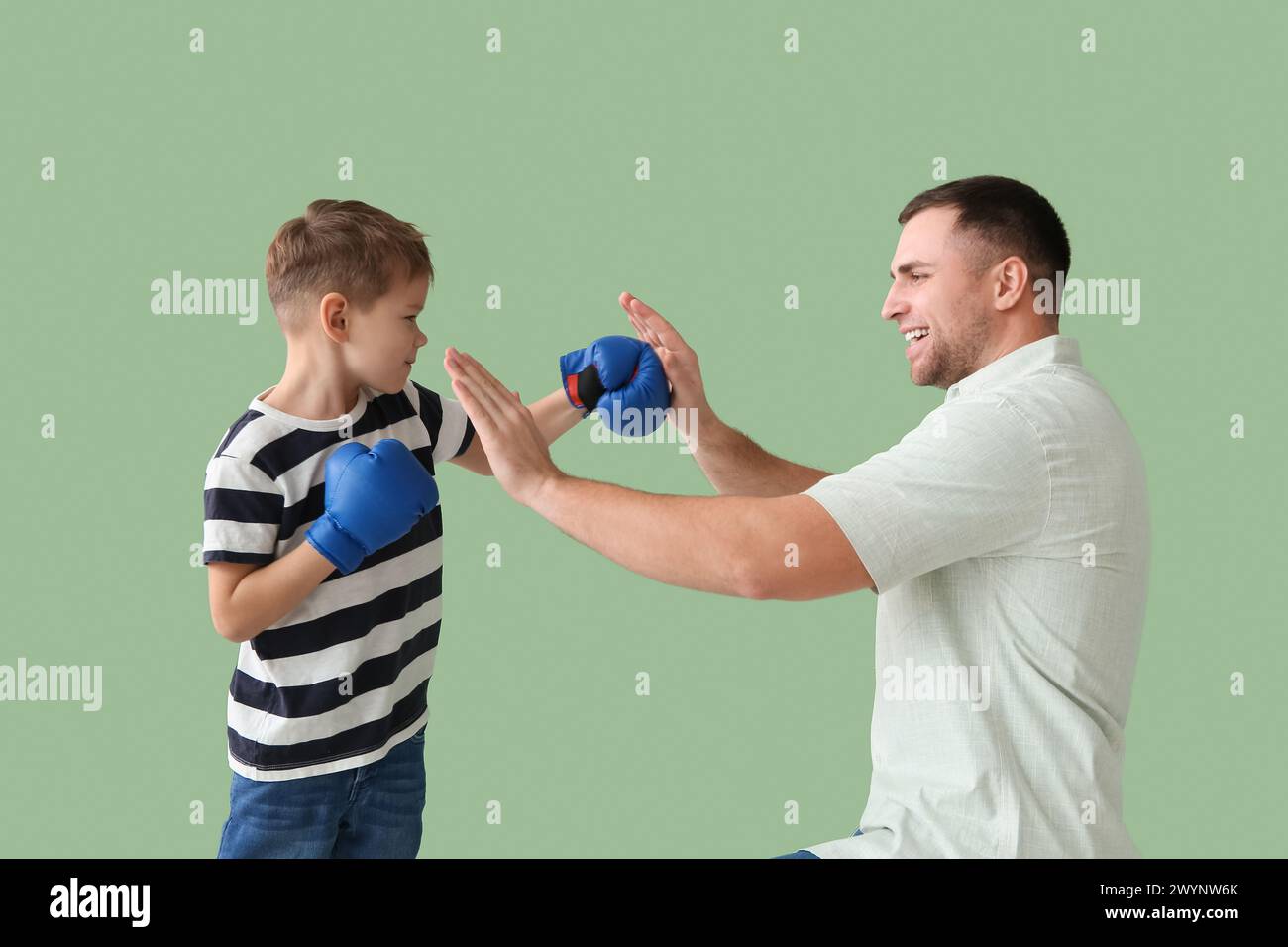 Happy father and his little son during boxing training on green ...