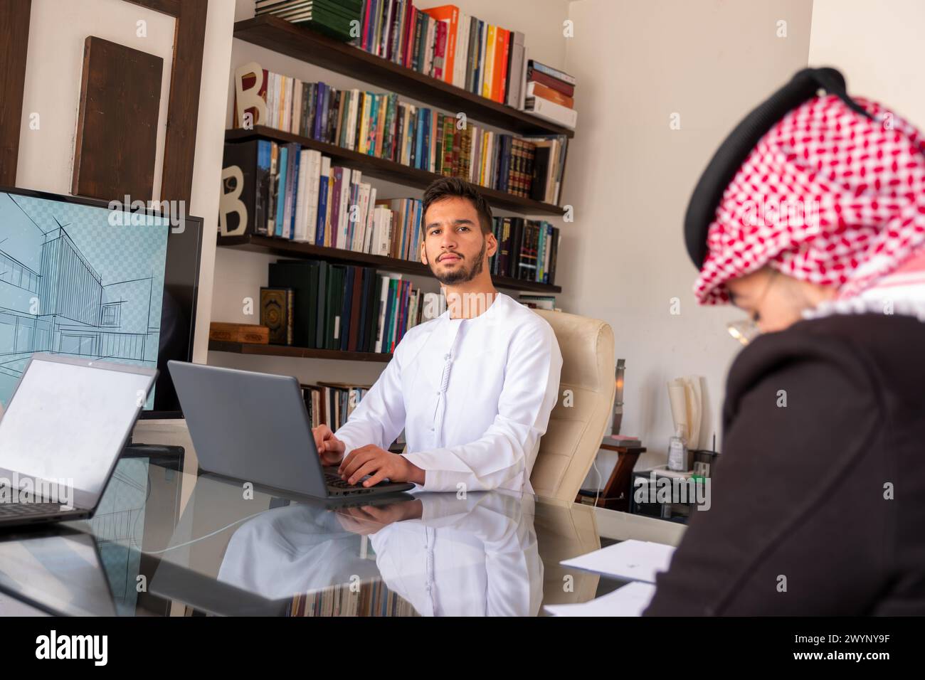 confident arabic male working on his laptop with modern background and ...