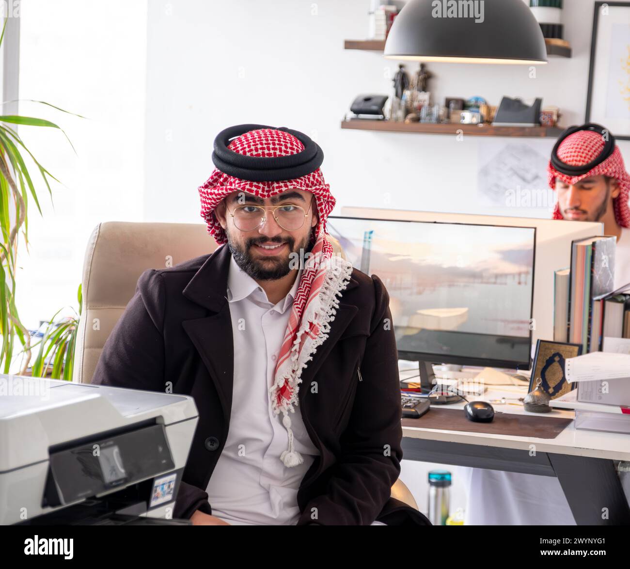 In an elegant office setting, an Arabic gentleman sits comfortably in ...
