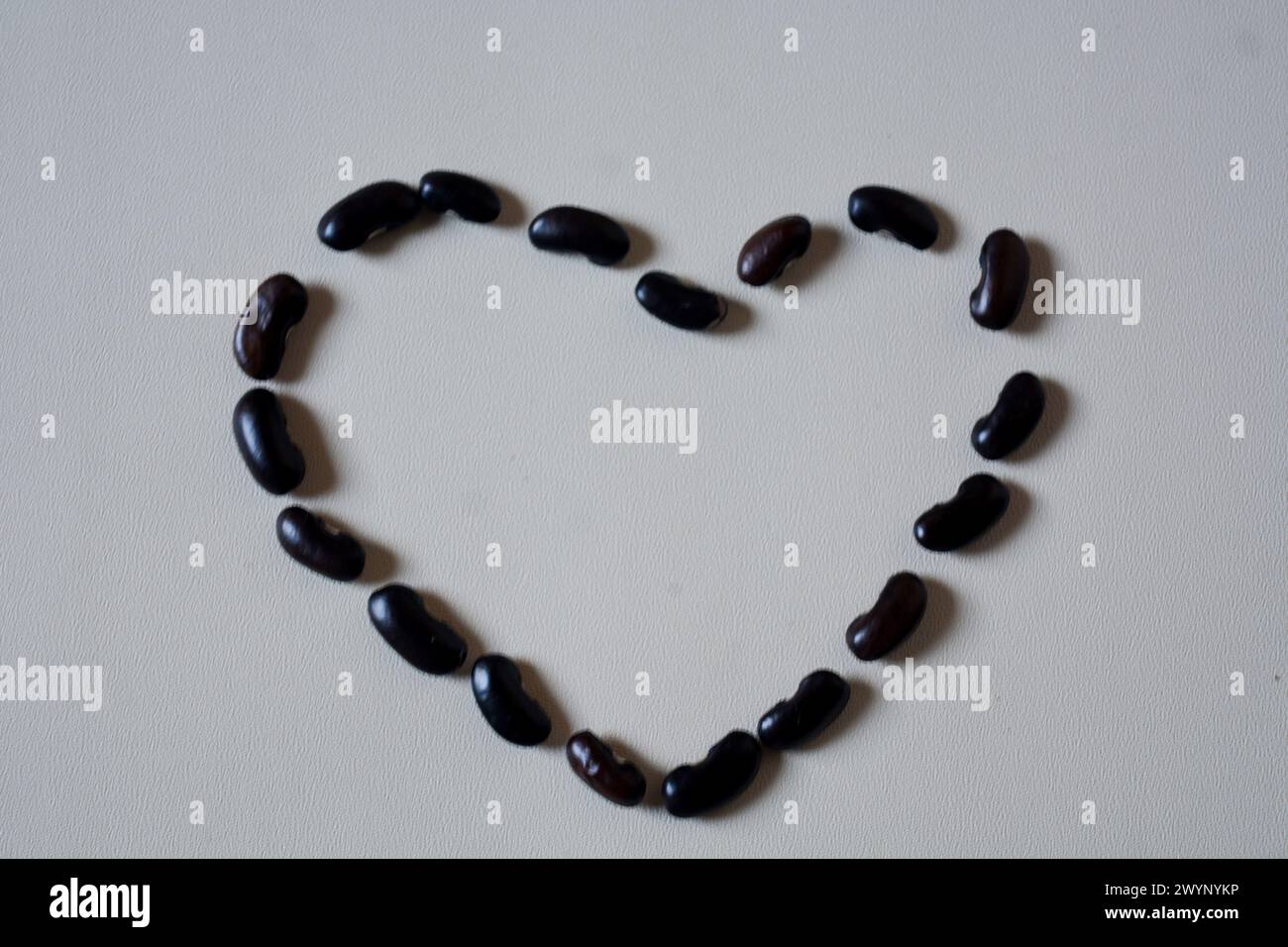 Heart-shaped black bean seeds on a white background Stock Photo - Alamy