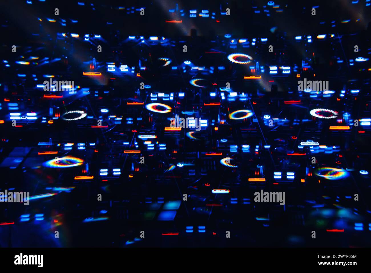 DJ mixer in a nightclub with a background of glowing lights from ...