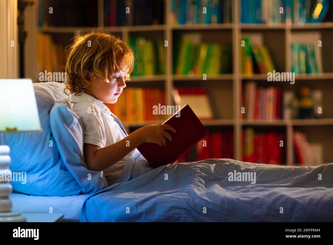 Child reading book in bed. Kids read at night. Little boy with fairy ...