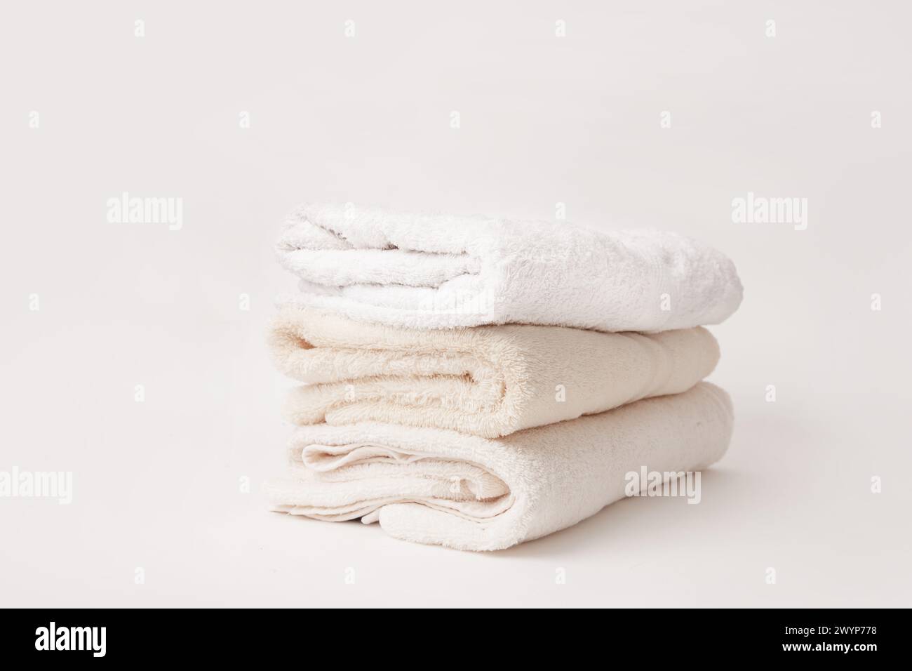 Clean beige soft bath towels stack on a white background Stock Photo ...