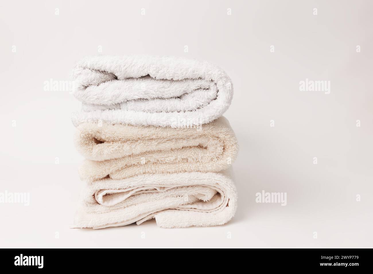 Clean beige soft bath towels stack on a white background Stock Photo ...