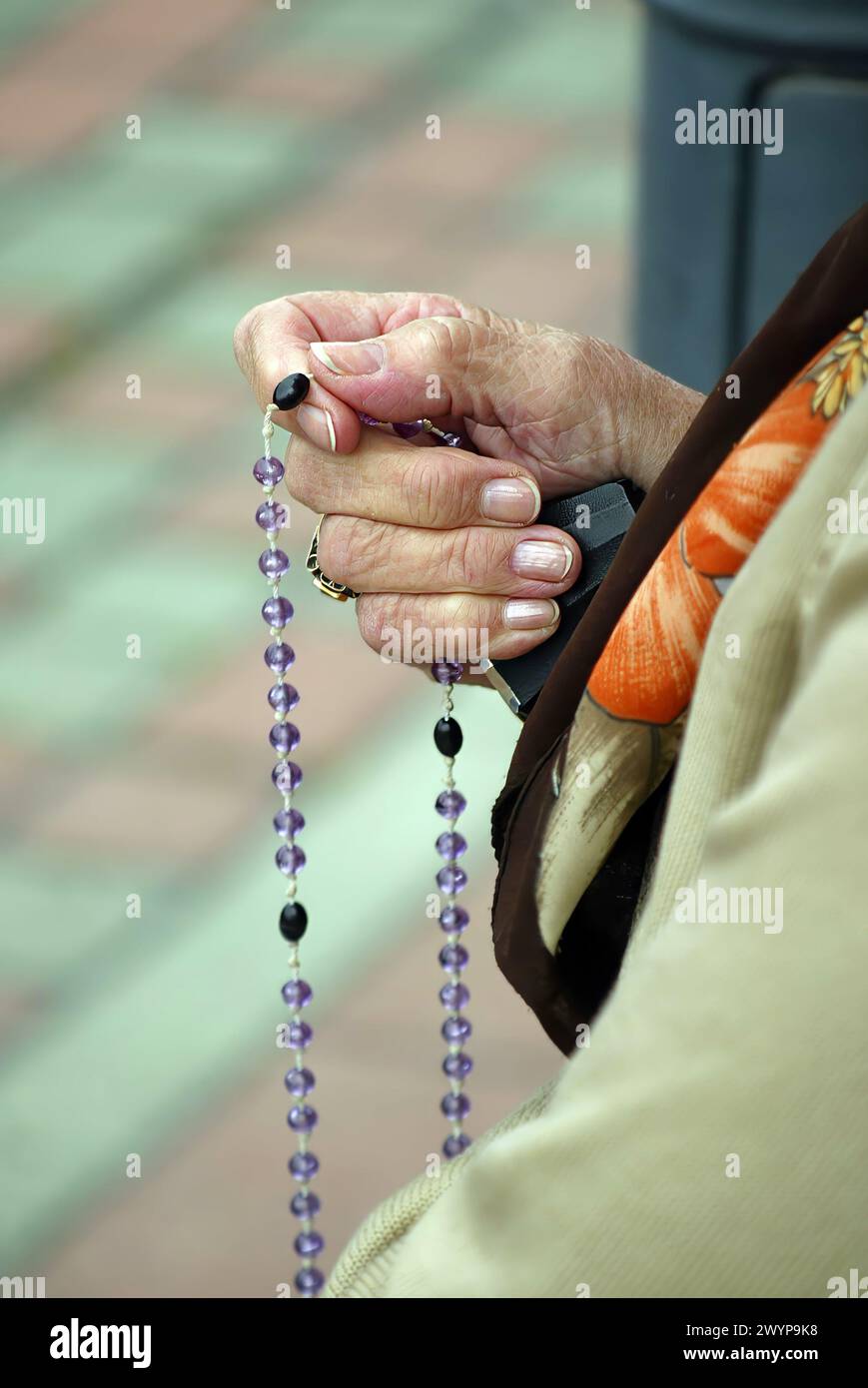 Hands of a woman holding a rosary while praying, Christian daily ...