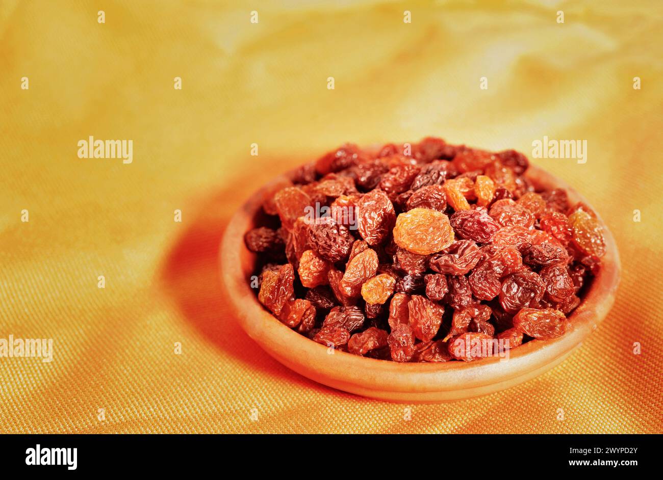 Bunch of raisins in bowl on colored background , dried grape fruit ...