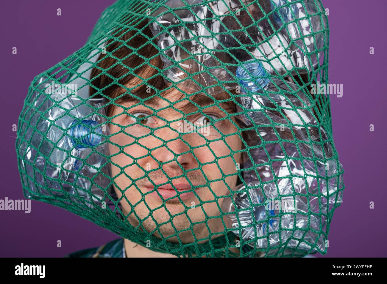 A powerful image capturing a person's face obscured by a net filled ...