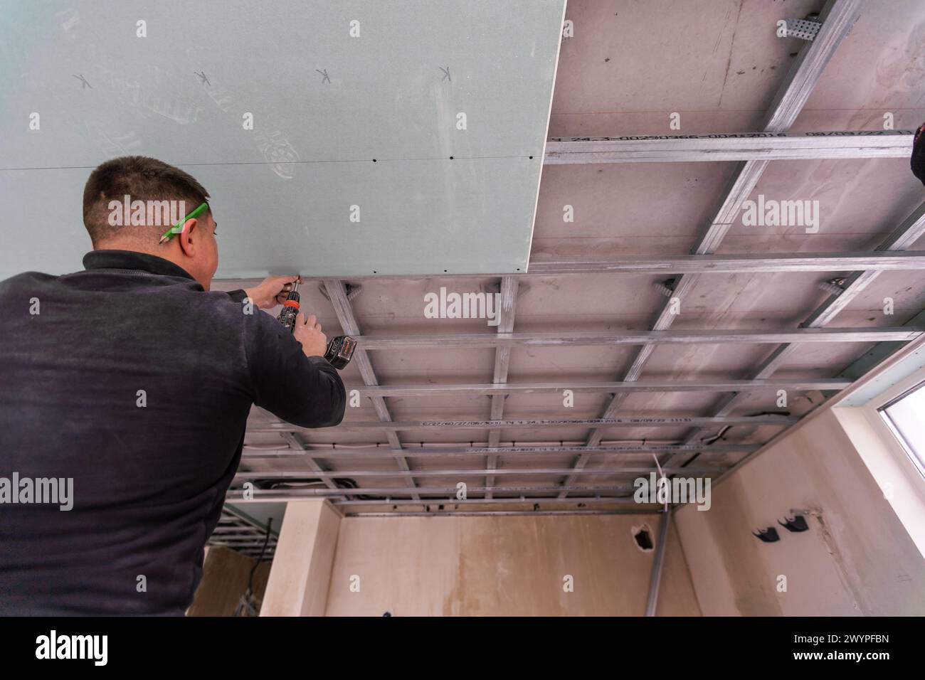 Construction worker, making walls from gypsum plasterboard or drywall ...