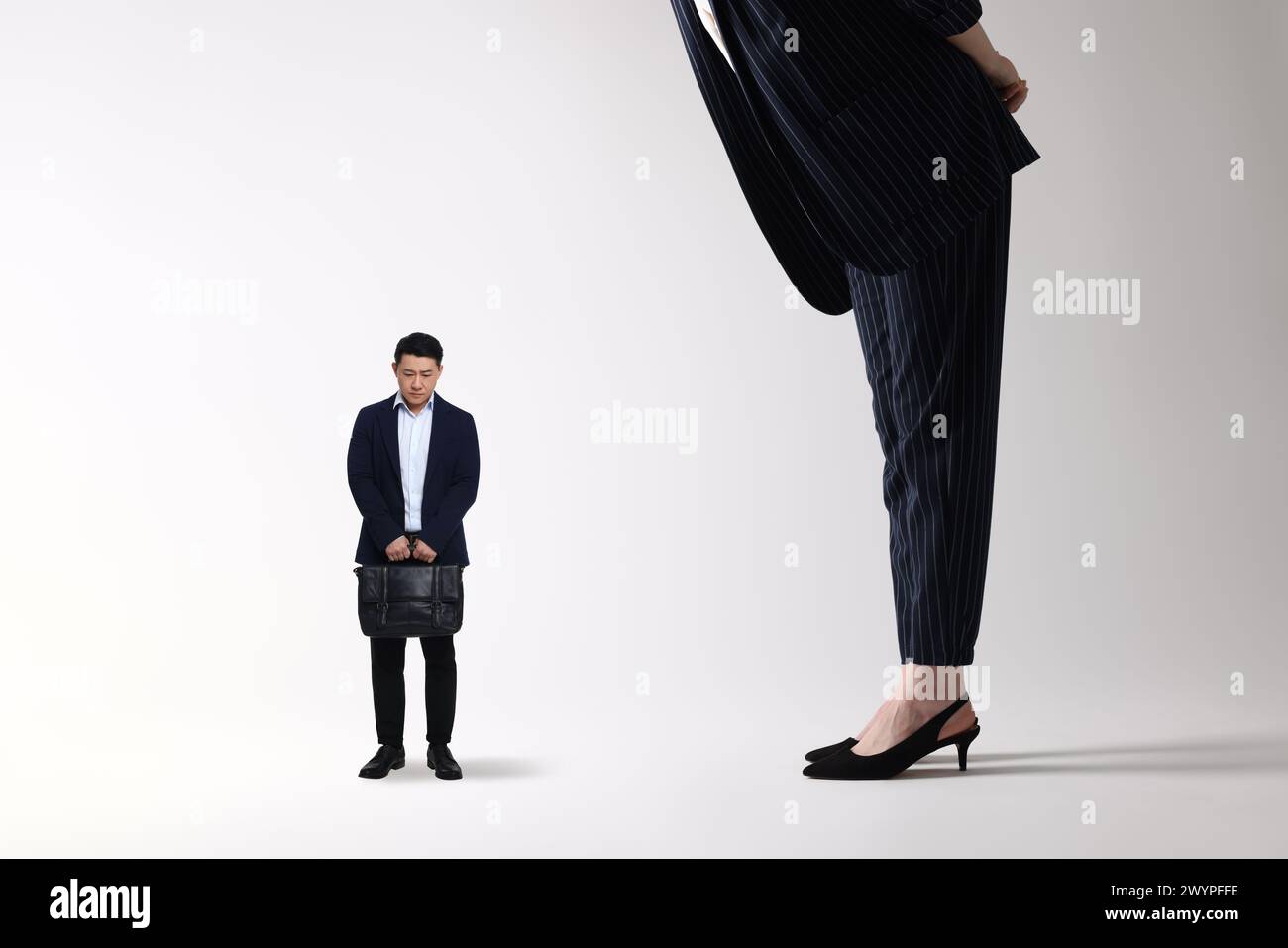 Giant woman and sad small man on light background Stock Photo - Alamy