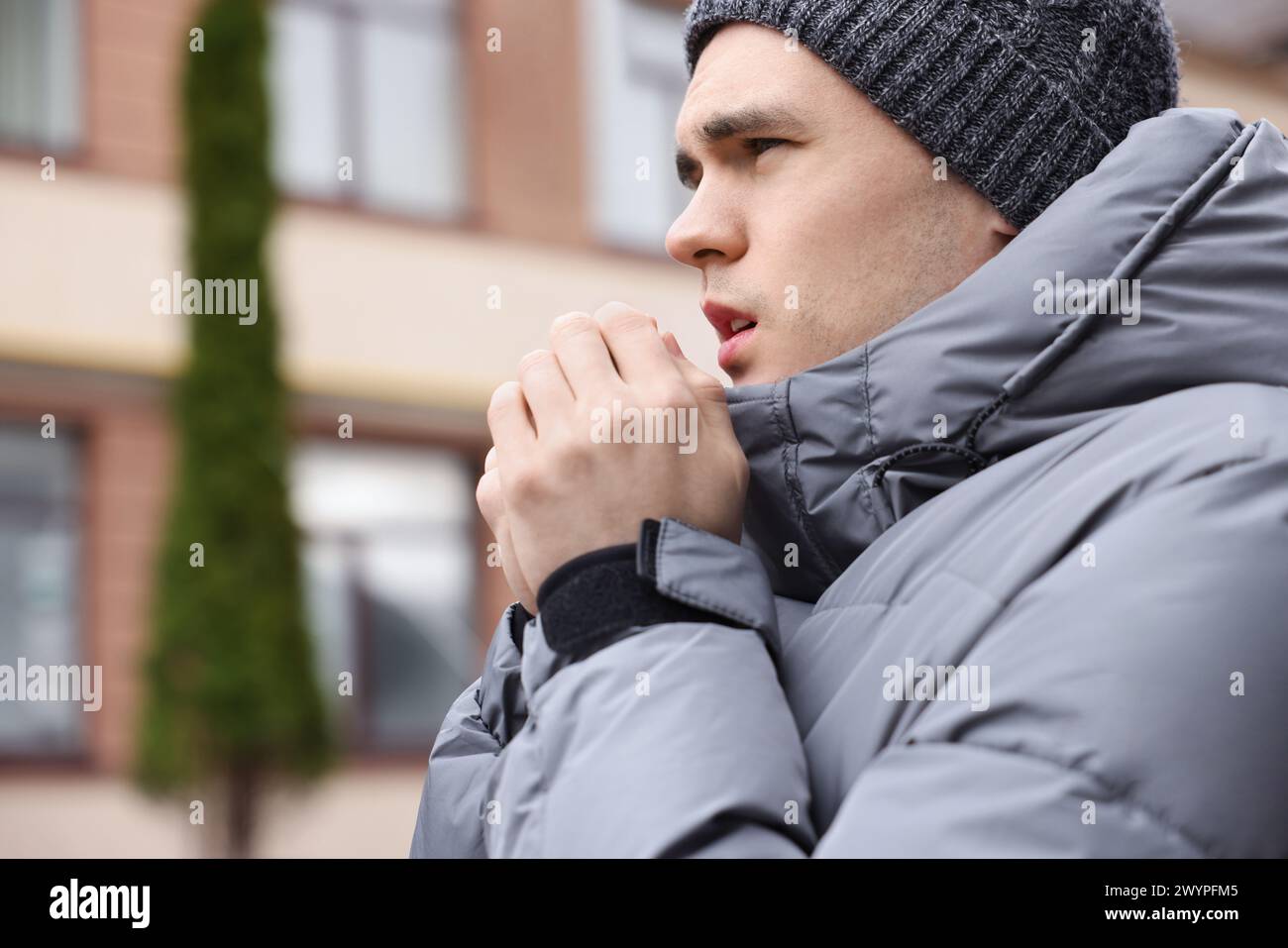 Sick young man coughing on city street. Cold symptoms Stock Photo - Alamy