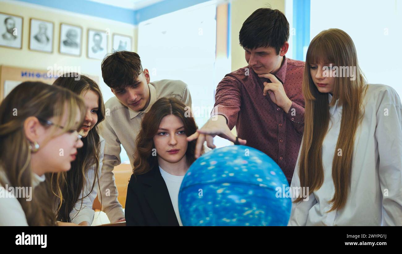 Students look at a globe of the starry sky in a classroom at school ...