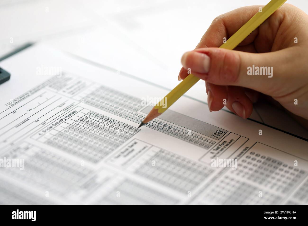 Female student hands testing in exercise and taking fill in exam paper ...