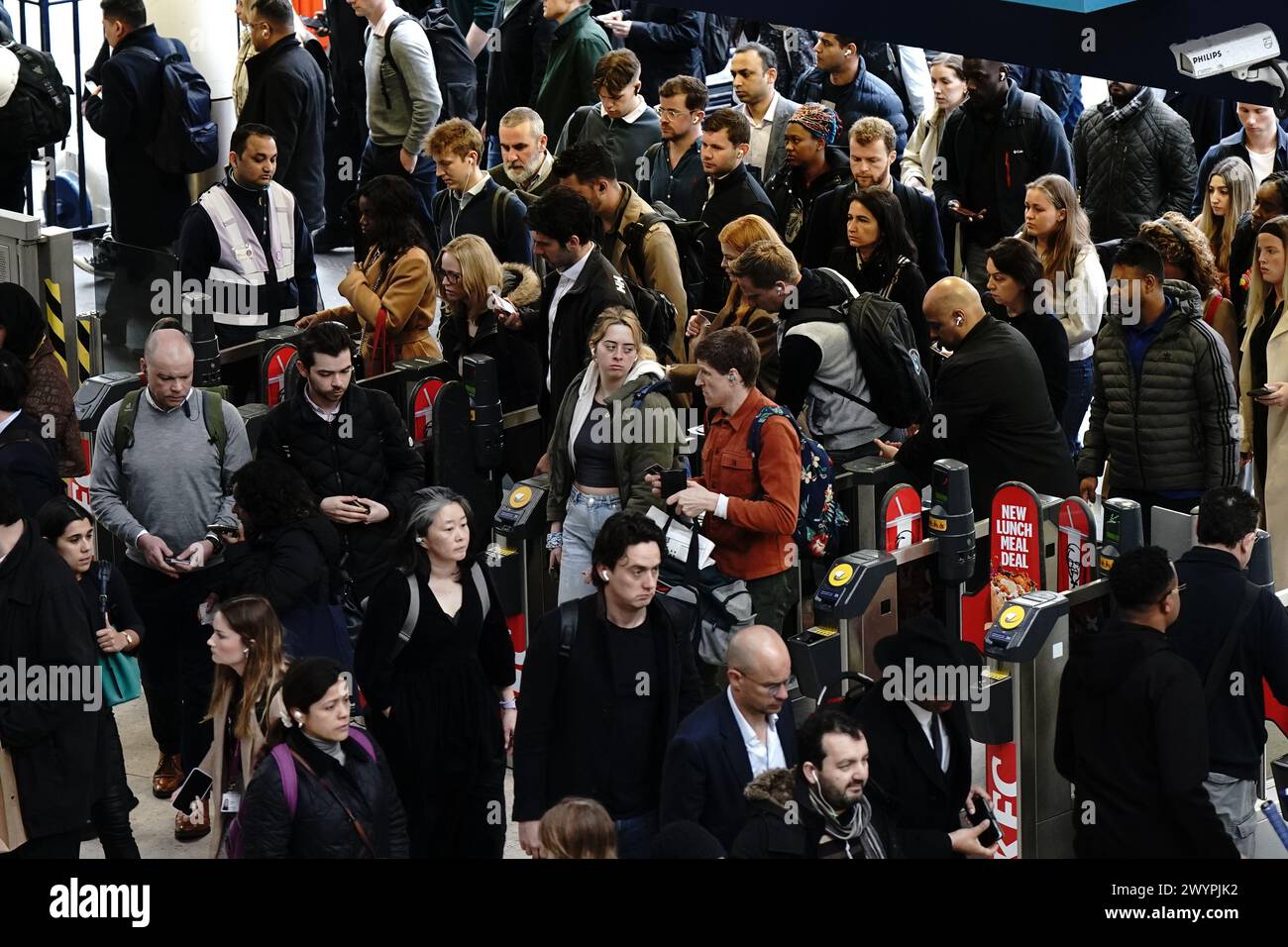 Passengers arrive at Waterloo train station in London, as members of ...