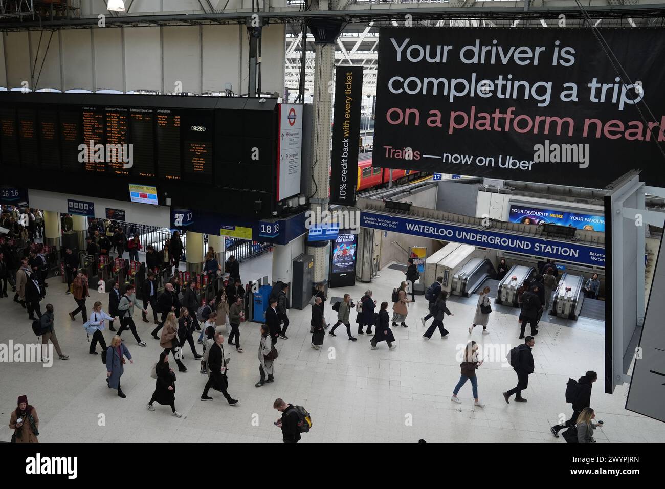 Passengers at Waterloo train station in London, as members of train ...