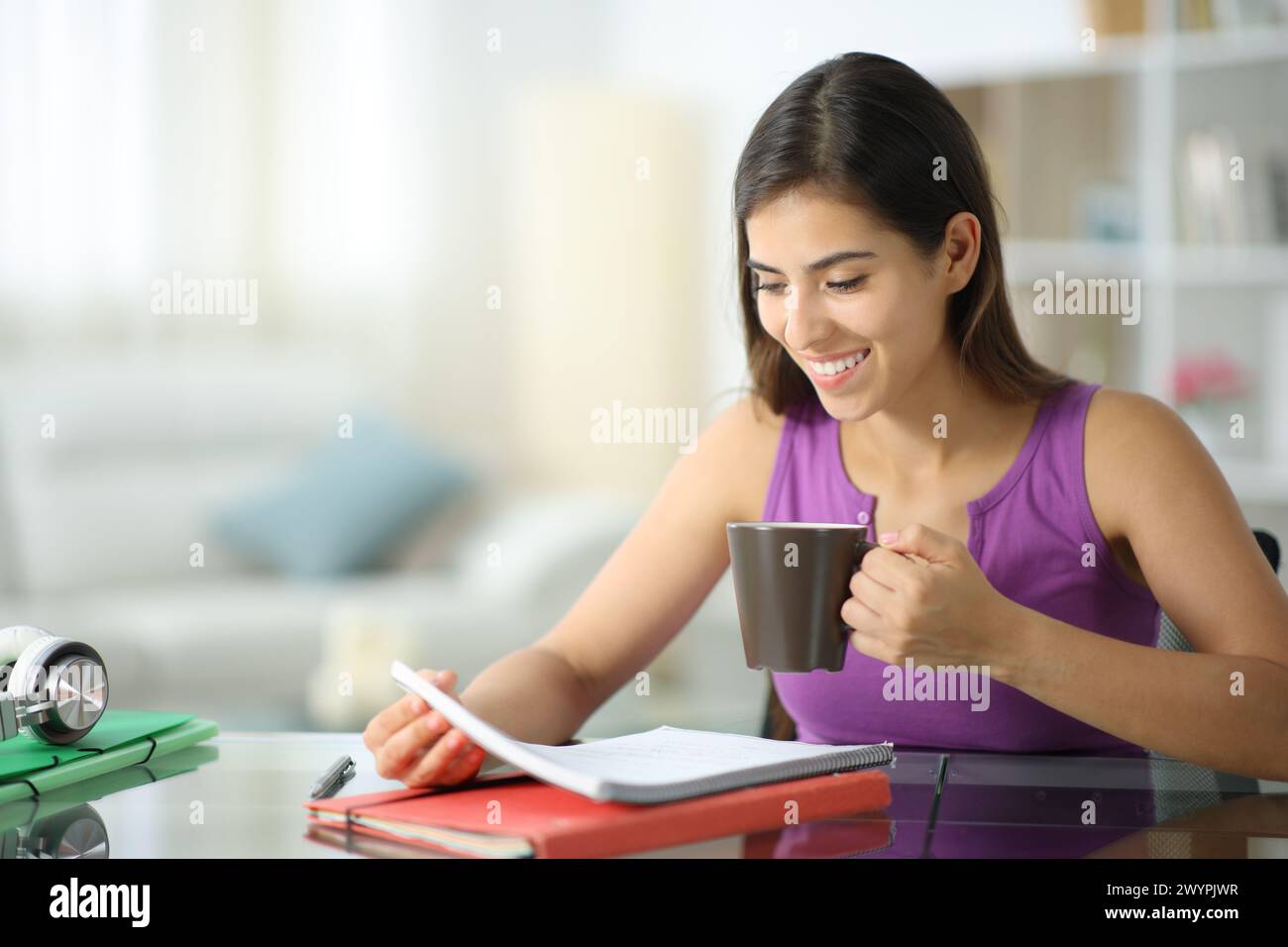 Happy student memorizing notes and drinking coffee at home Stock Photo ...
